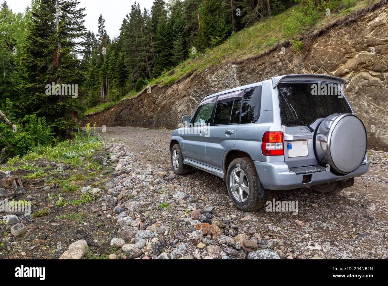 Off-road 4x4 car driving on a narrow gravel road to Zekari Pass ...