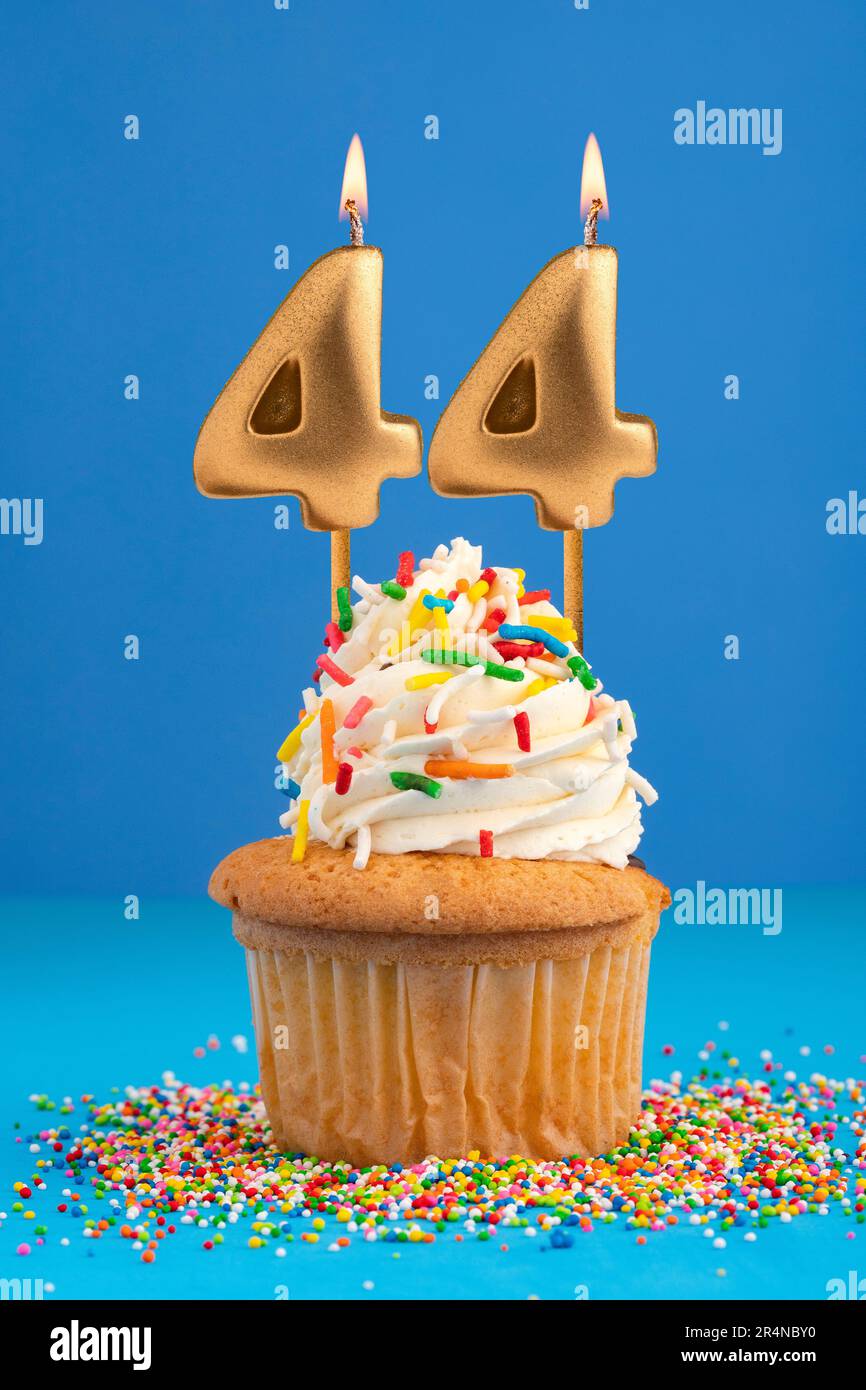 Birthday cake with candle number 44 - Blue background Stock Photo - Alamy