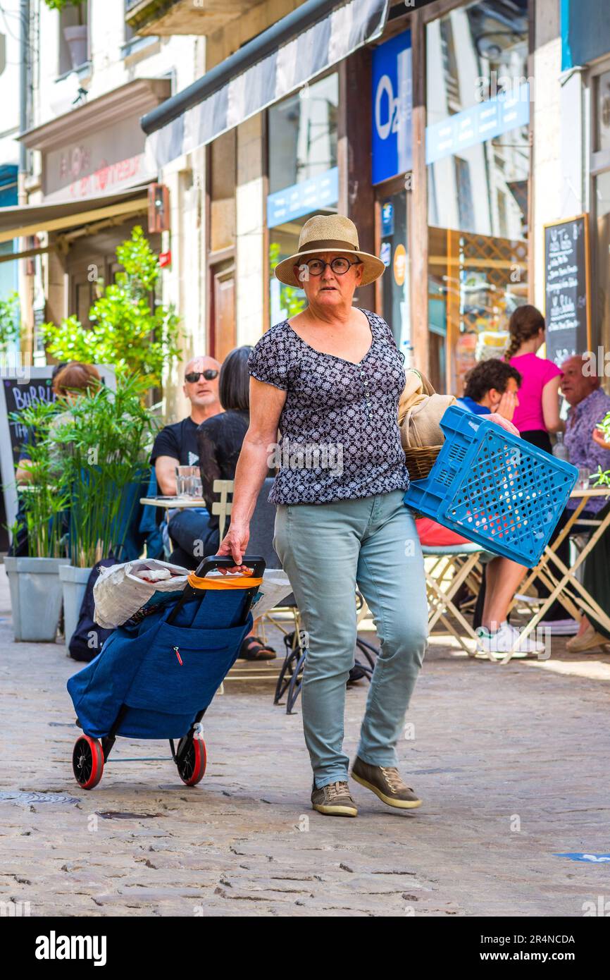 Middle-aged woman pulling shopping cart along town street - Loches ...