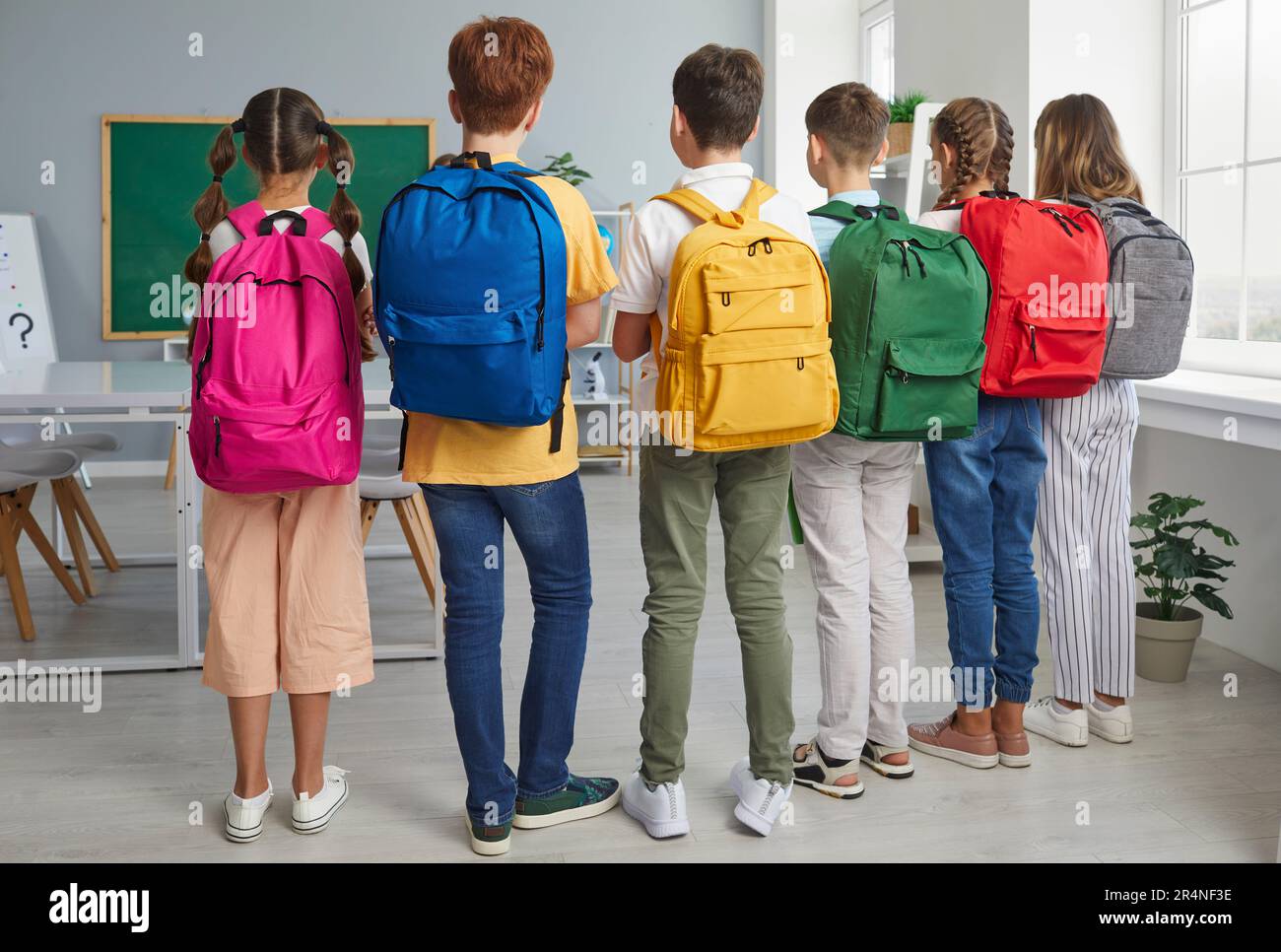 Back view of school students with colorful backpacks standing together ...