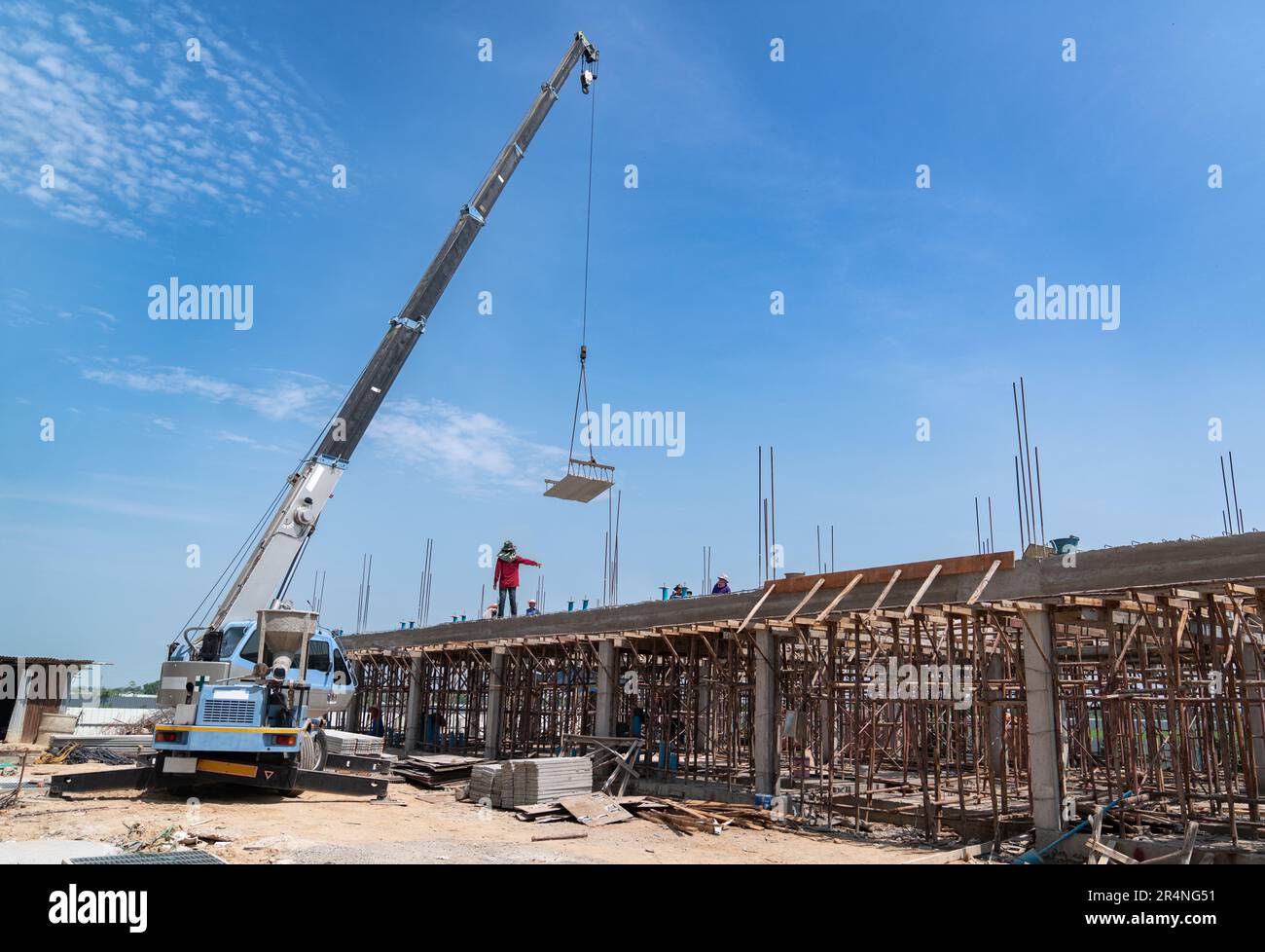 Workers signal cranes to lift materials to work at height. Powered by ...