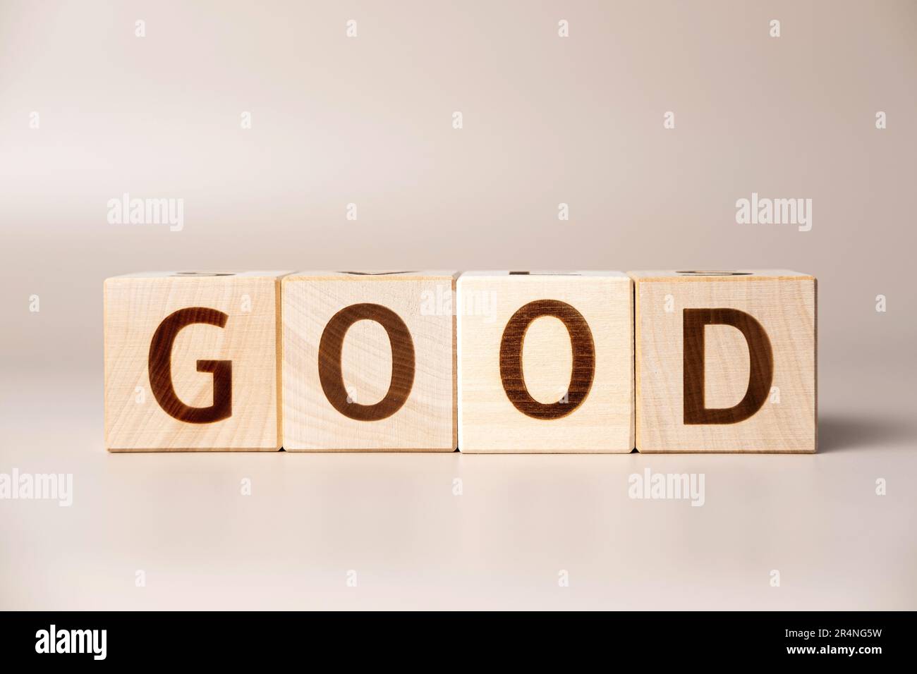 The word GOOD on wooden cubes on a beige neutral studio background ...