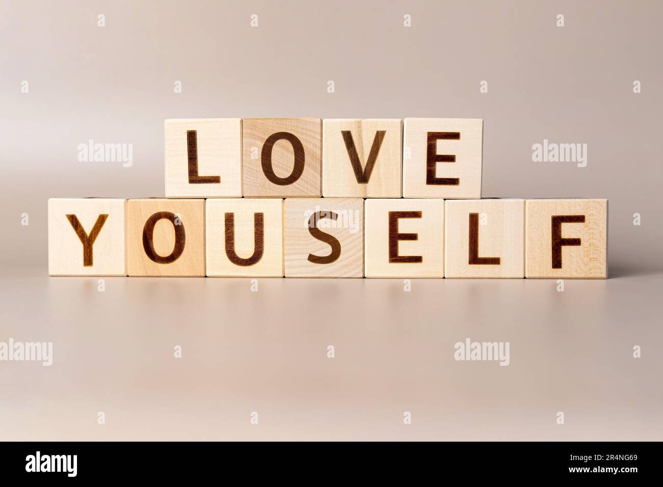 The word LOVE YOURSELF on wooden cubes on a beige neutral studio ...