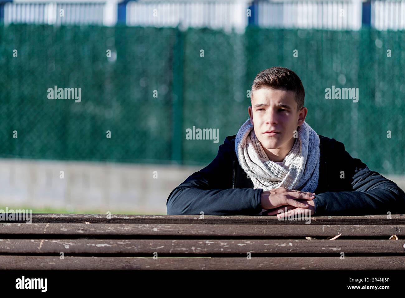 Teenager leaning on park bench looking away Stock Photo - Alamy
