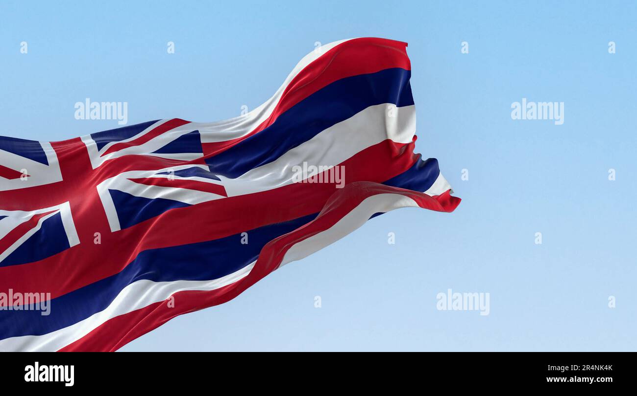 The flag of Hawaii waving in the wind on a clear day. Eight horizontal ...