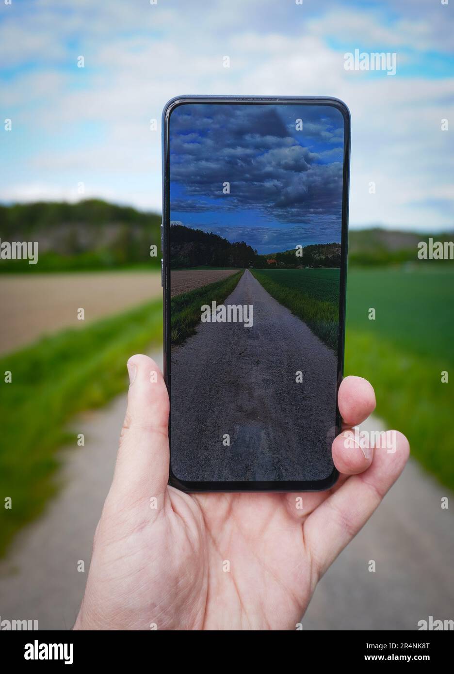 Cropped hand photographing with mobile phone on road Stock Photo - Alamy