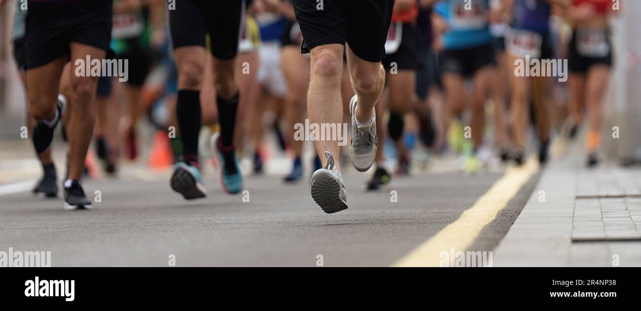 Marathon runners running on city road, large group of runners Stock ...