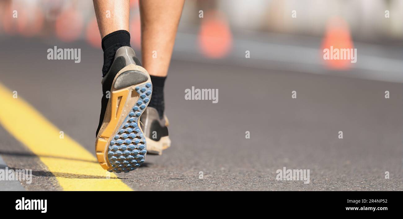 Athlete runner, feet running on road close up on shoe, marathon running ...