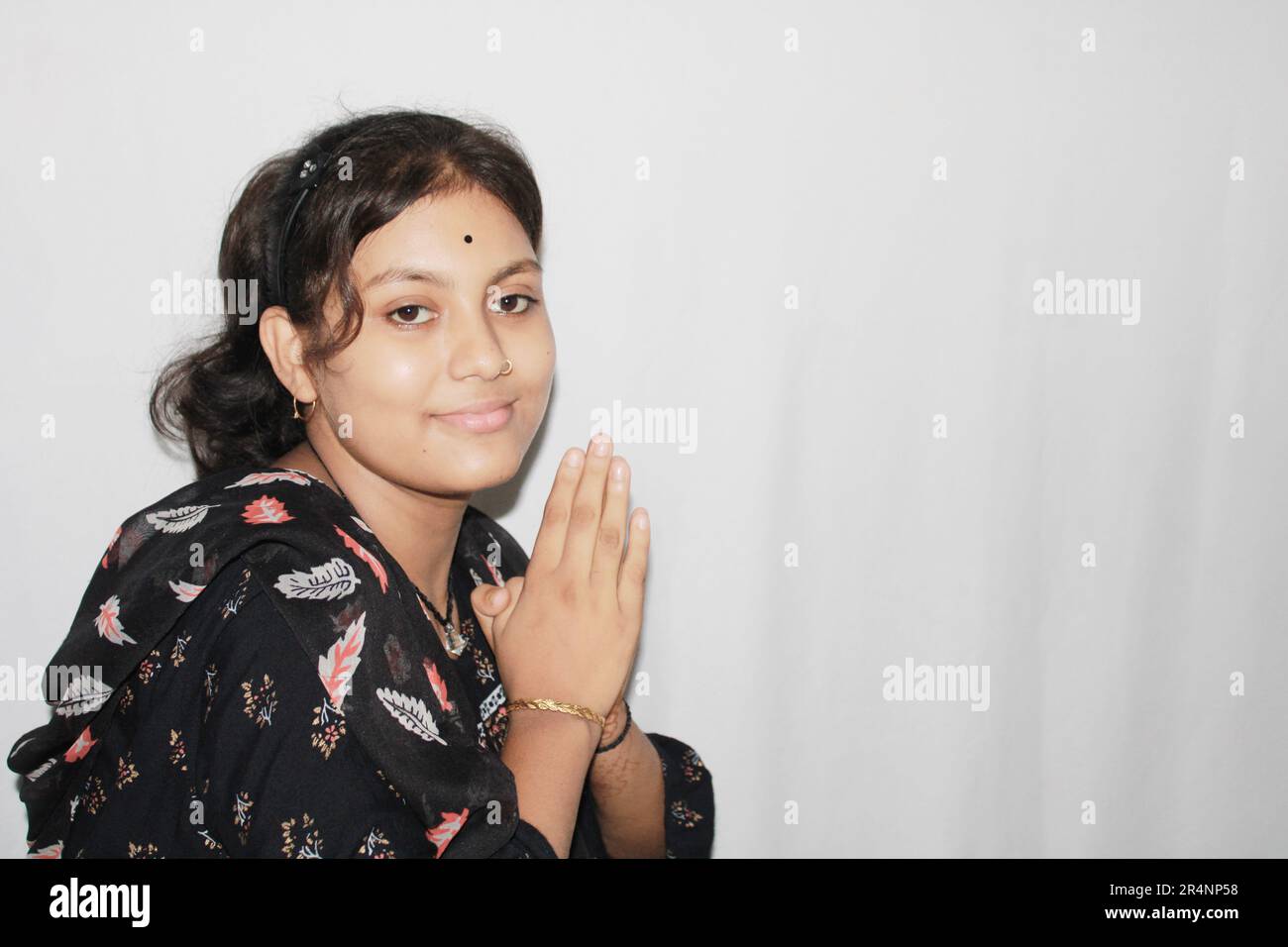 Namaste Portrait of happy Indian girl, white background Stock Photo - Alamy