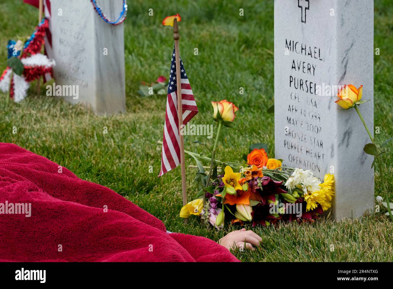 Avery Carlin, of Arlington, Va., rests by the headstone of her uncle U ...