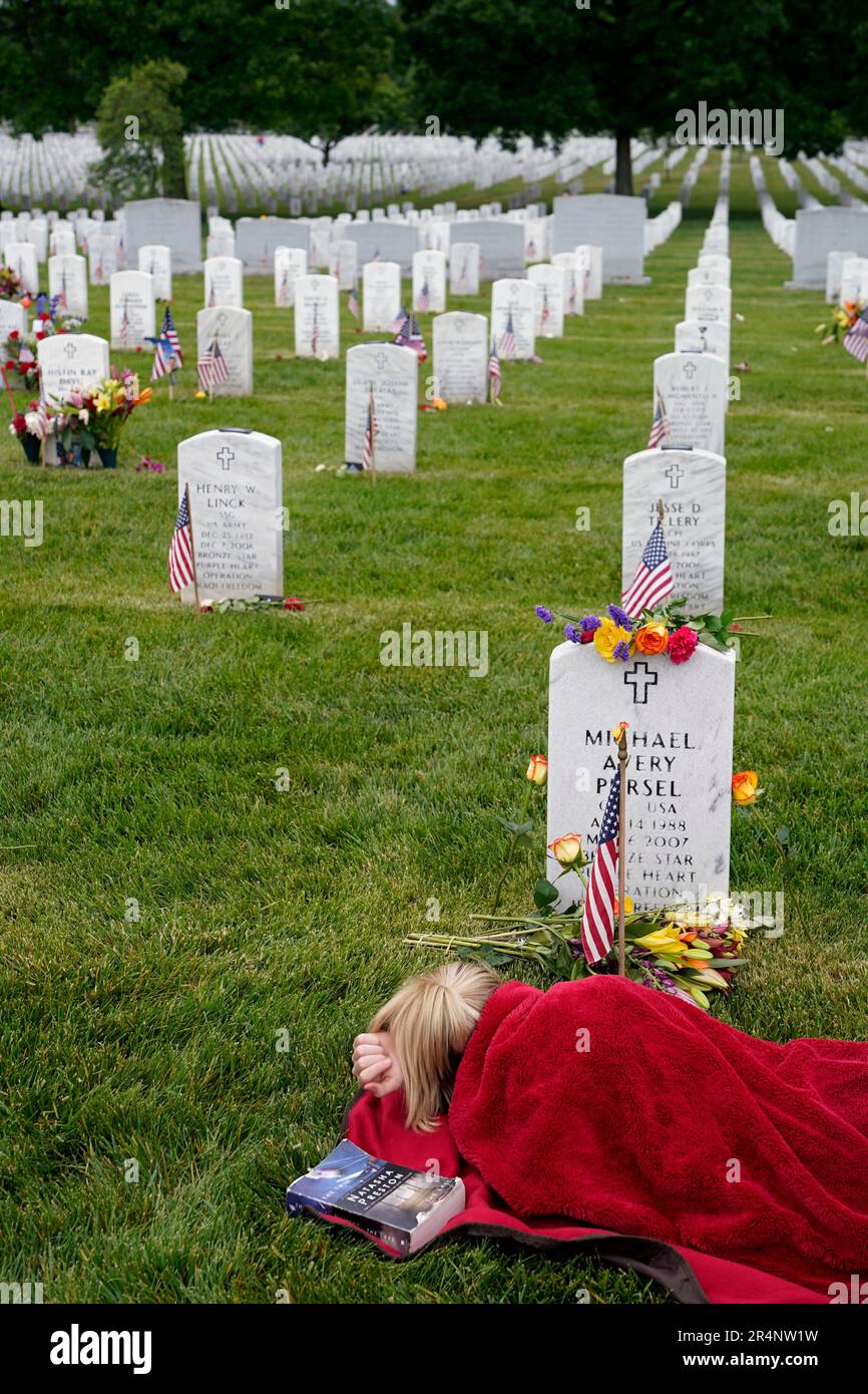 Avery Carlin, of Arlington, Va., rests by the headstone of her uncle U ...