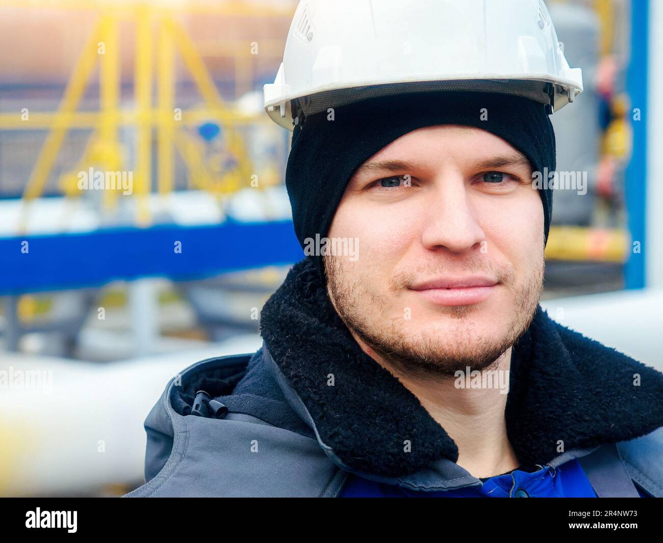 Face of young builder in hard hat close-up. Authentic worker looks ...