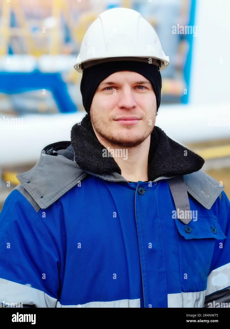 Portrait of caucasian builder in white hard hat and winter pea coat ...