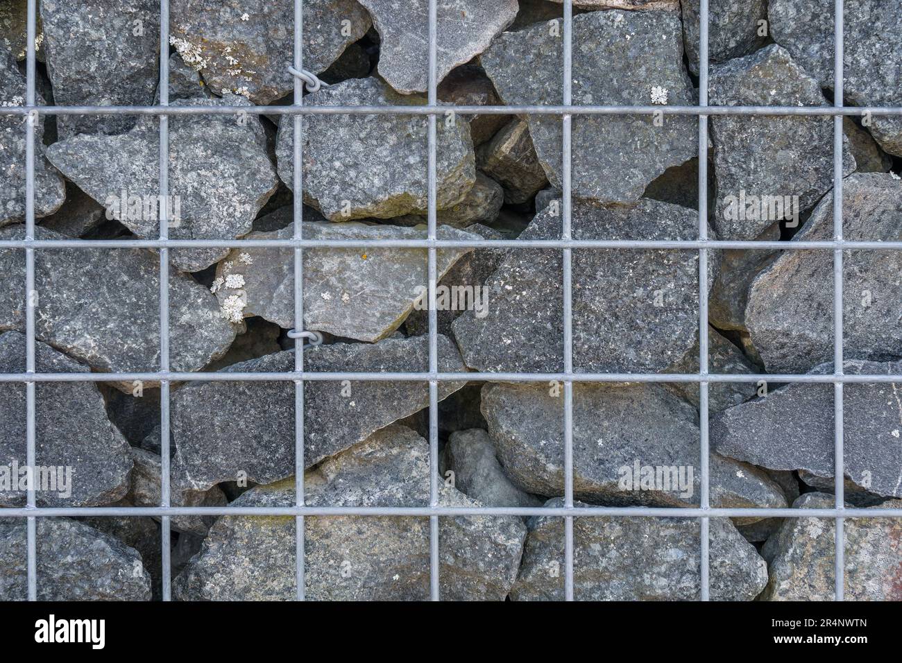 Stones behind the metal grating, stone wall background Stock Photo - Alamy