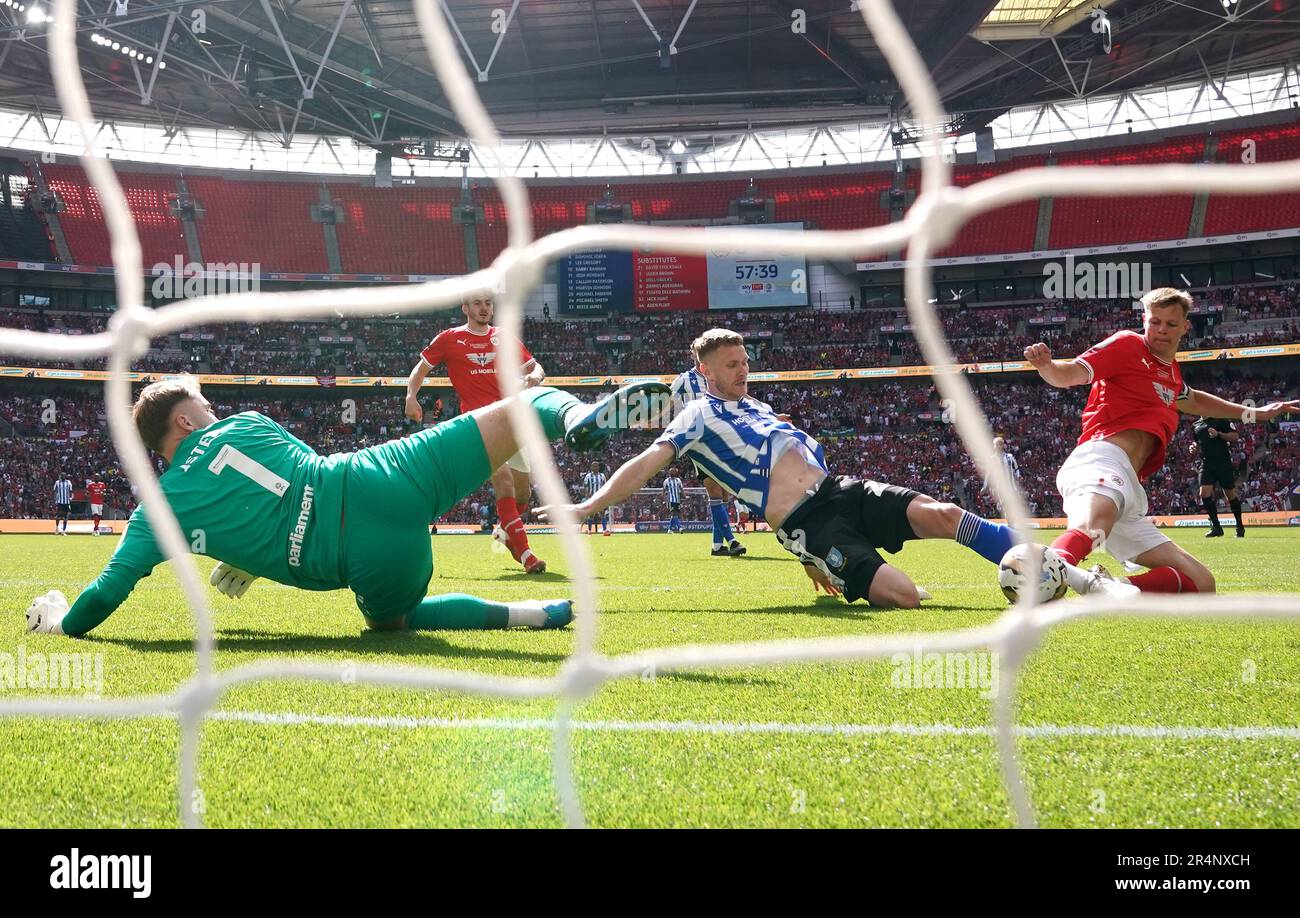 Barnsley goalkeeper Harry Isted (left) makes a save from Sheffield ...