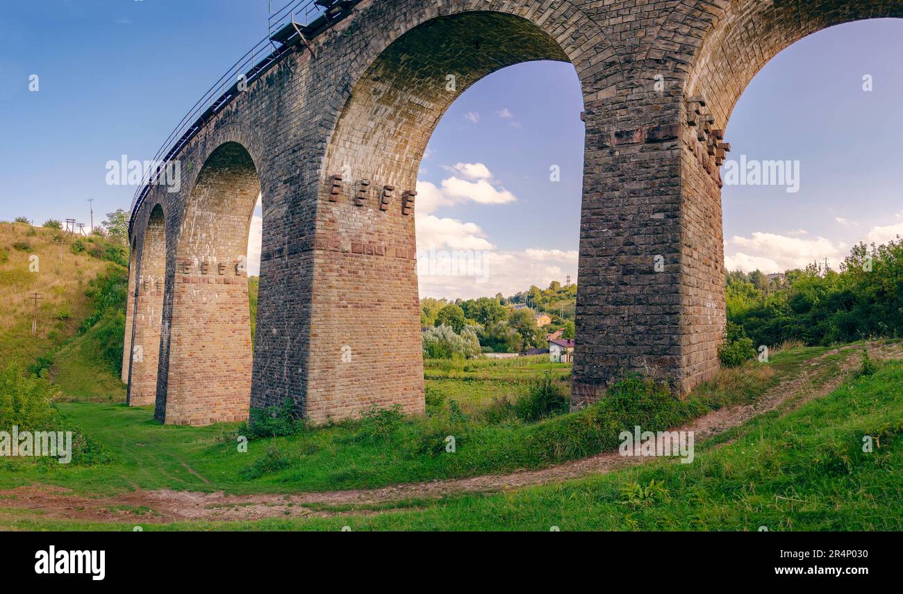 Stone railway ancient arch bridge over green valley Stock Photo - Alamy