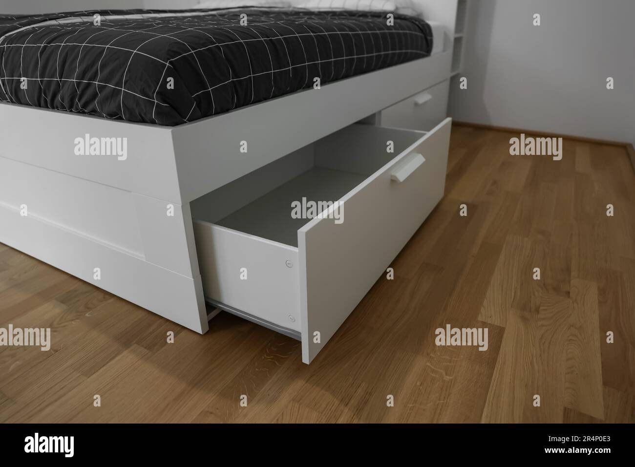 Modern bed with open drawer in room Stock Photo - Alamy