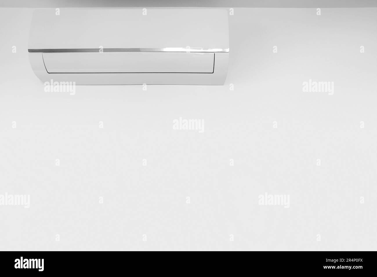 Modern air conditioner hanging on light wall in room Stock Photo - Alamy