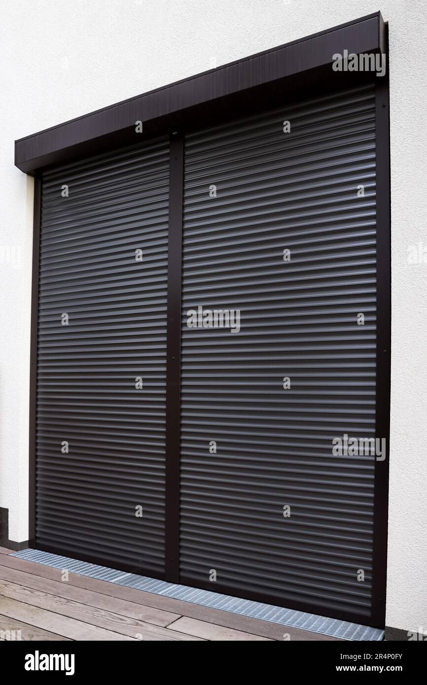View of building with big windows and black roller shutters outdoors ...