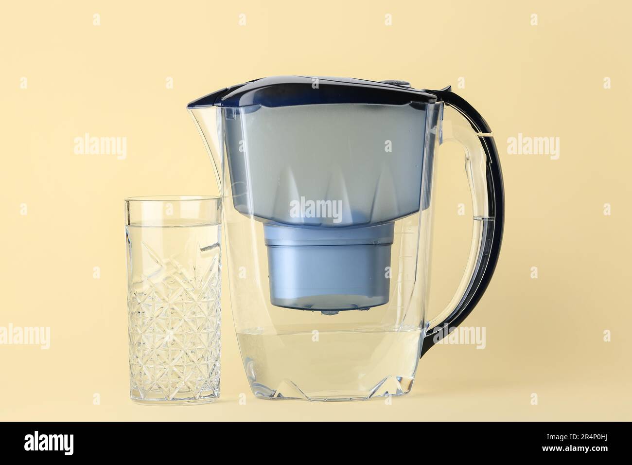 Water filter jug with glass on beige background Stock Photo - Alamy