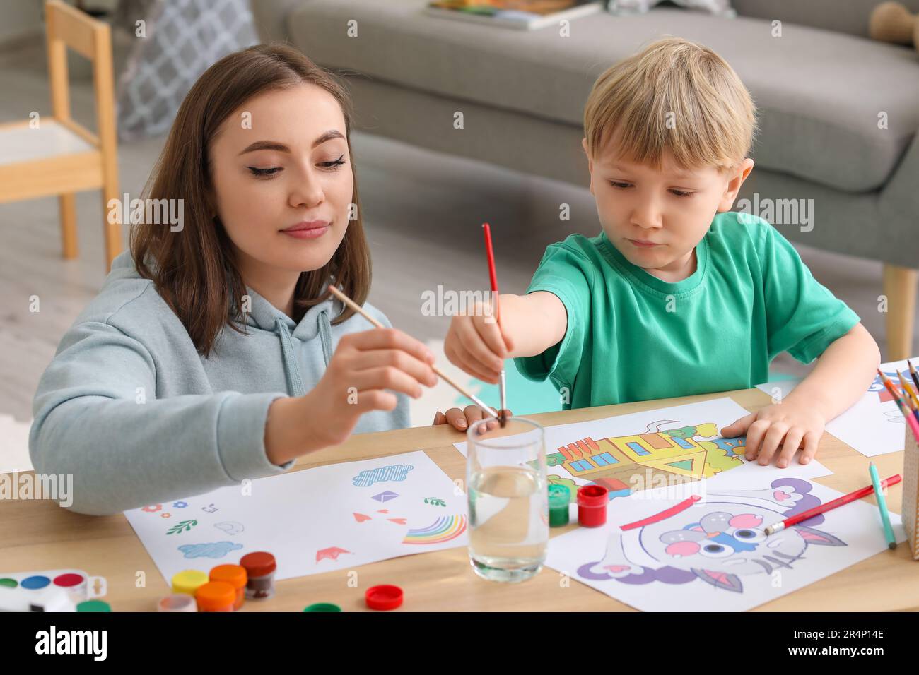 Nanny with little boy drawing at home Stock Photo - Alamy
