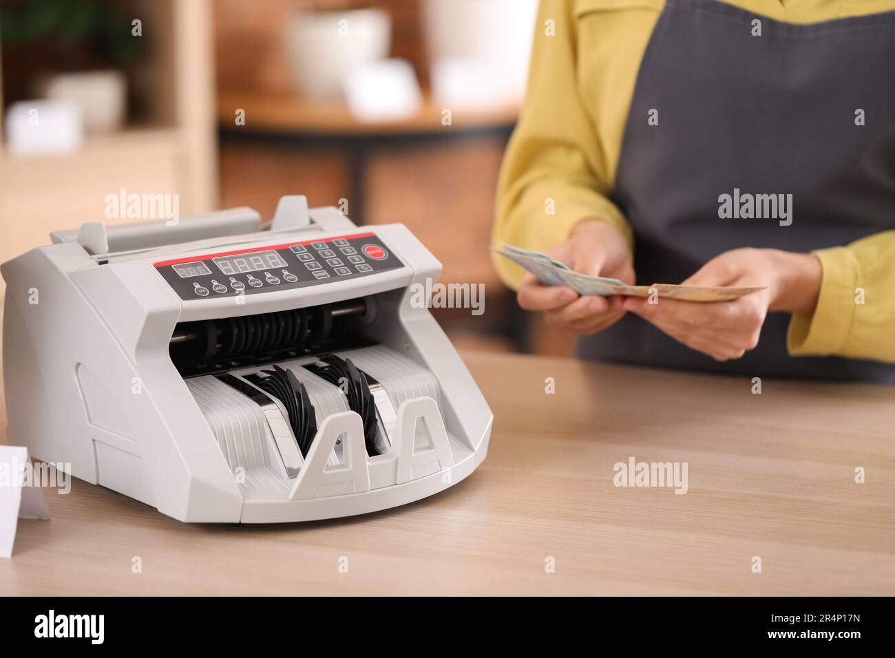 Female cashier counting money。 hi-res stock photography and images - Alamy