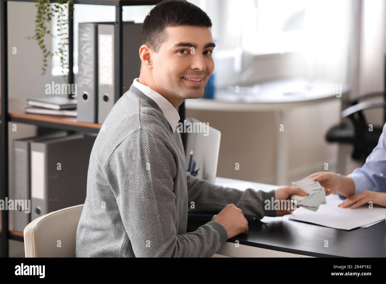Young man giving money counting hi-res stock photography and images - Alamy