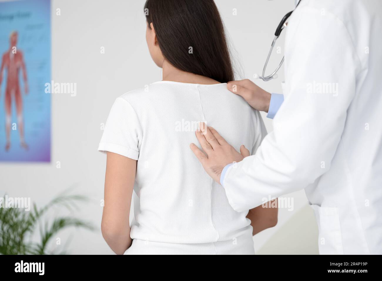 Male doctor checking posture of young woman in clinic Stock Photo - Alamy