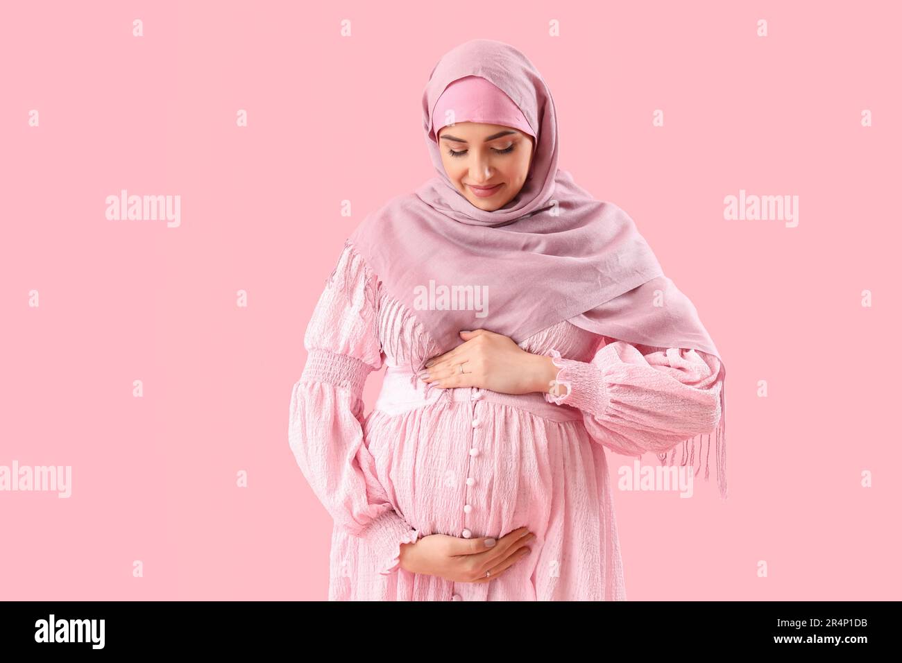 Young pregnant Muslim woman on pink background Stock Photo - Alamy