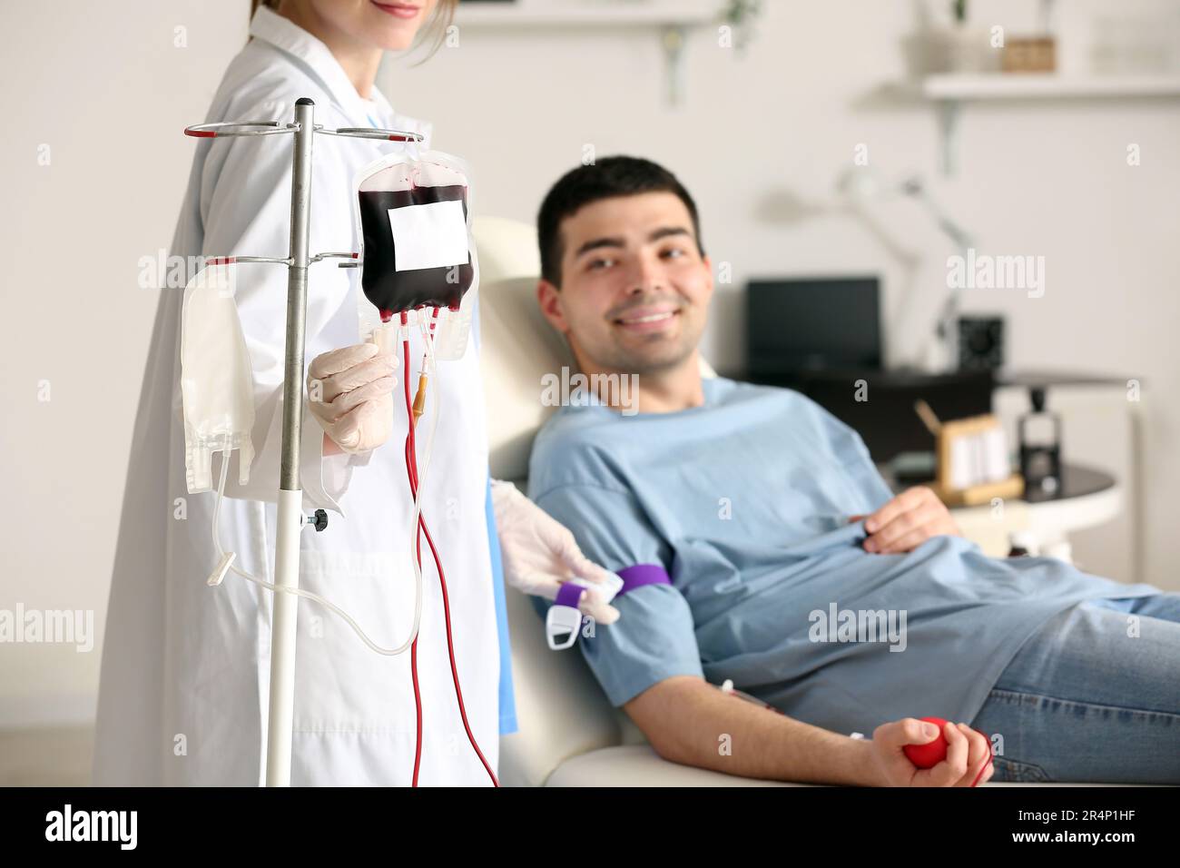 Female doctor taking blood from young donor in clinic Stock Photo - Alamy