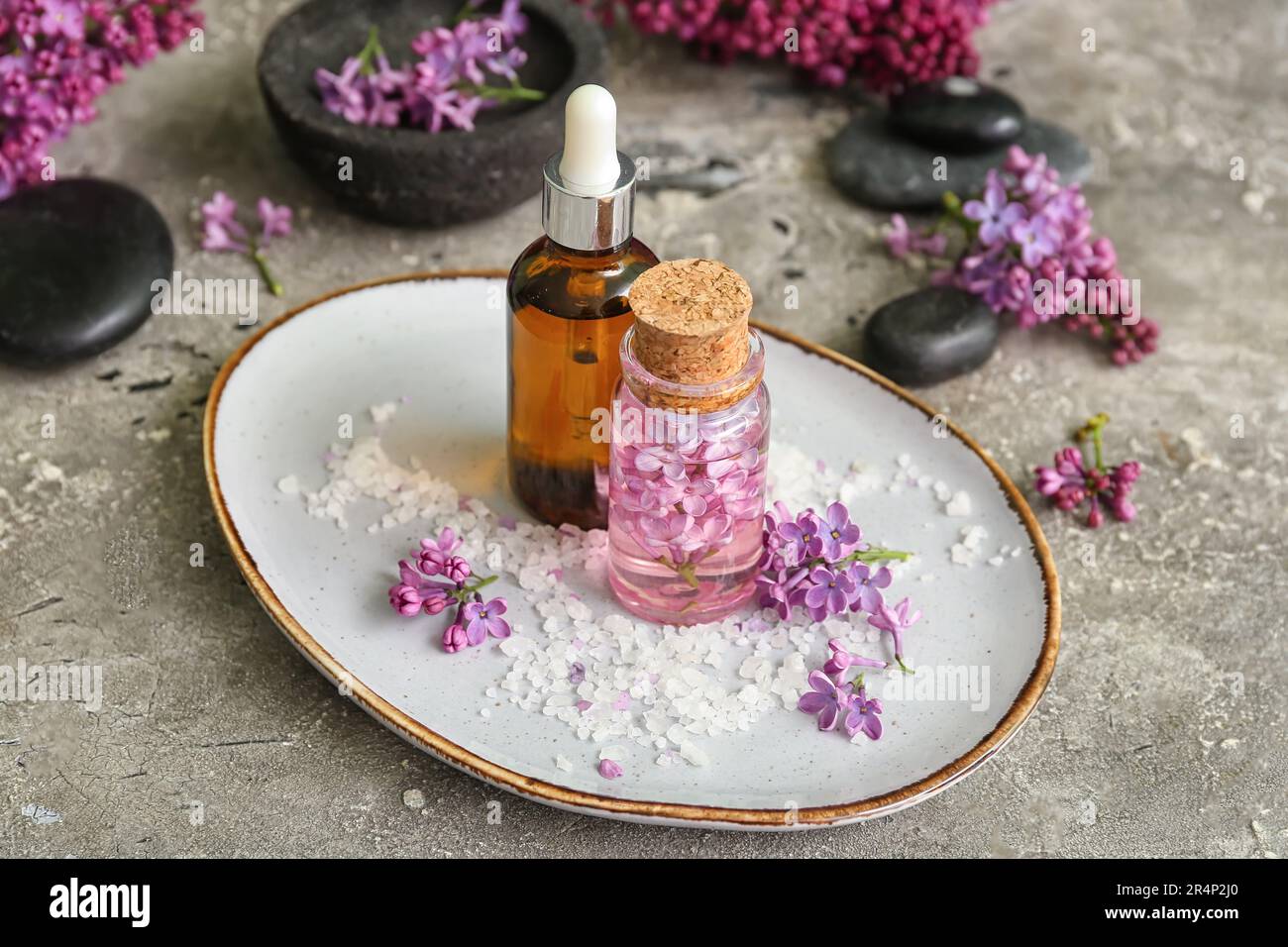 Bottles of cosmetic oil with beautiful lilac flowers and sea salt on ...