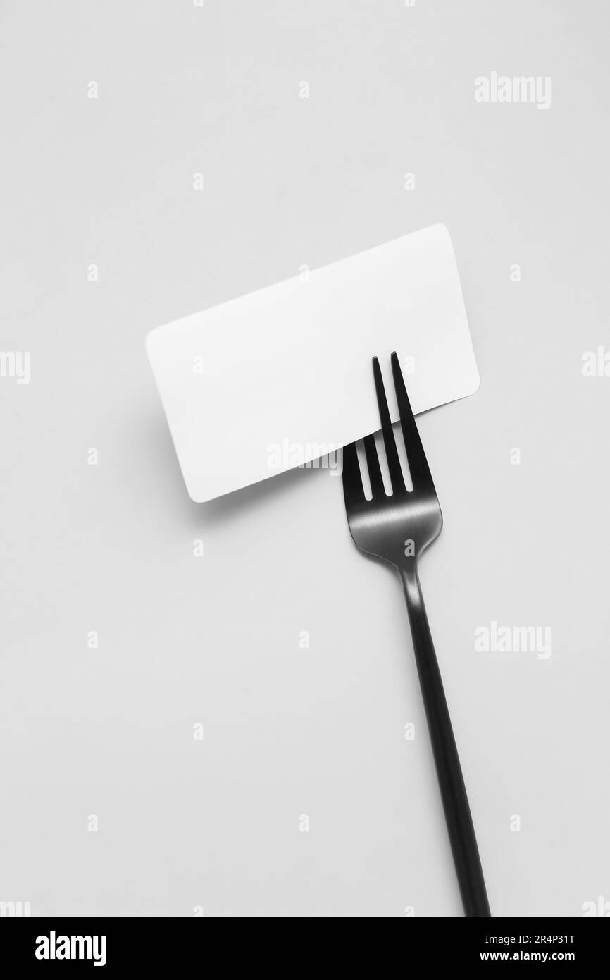 Blank card and stainless steel fork on white background Stock Photo - Alamy