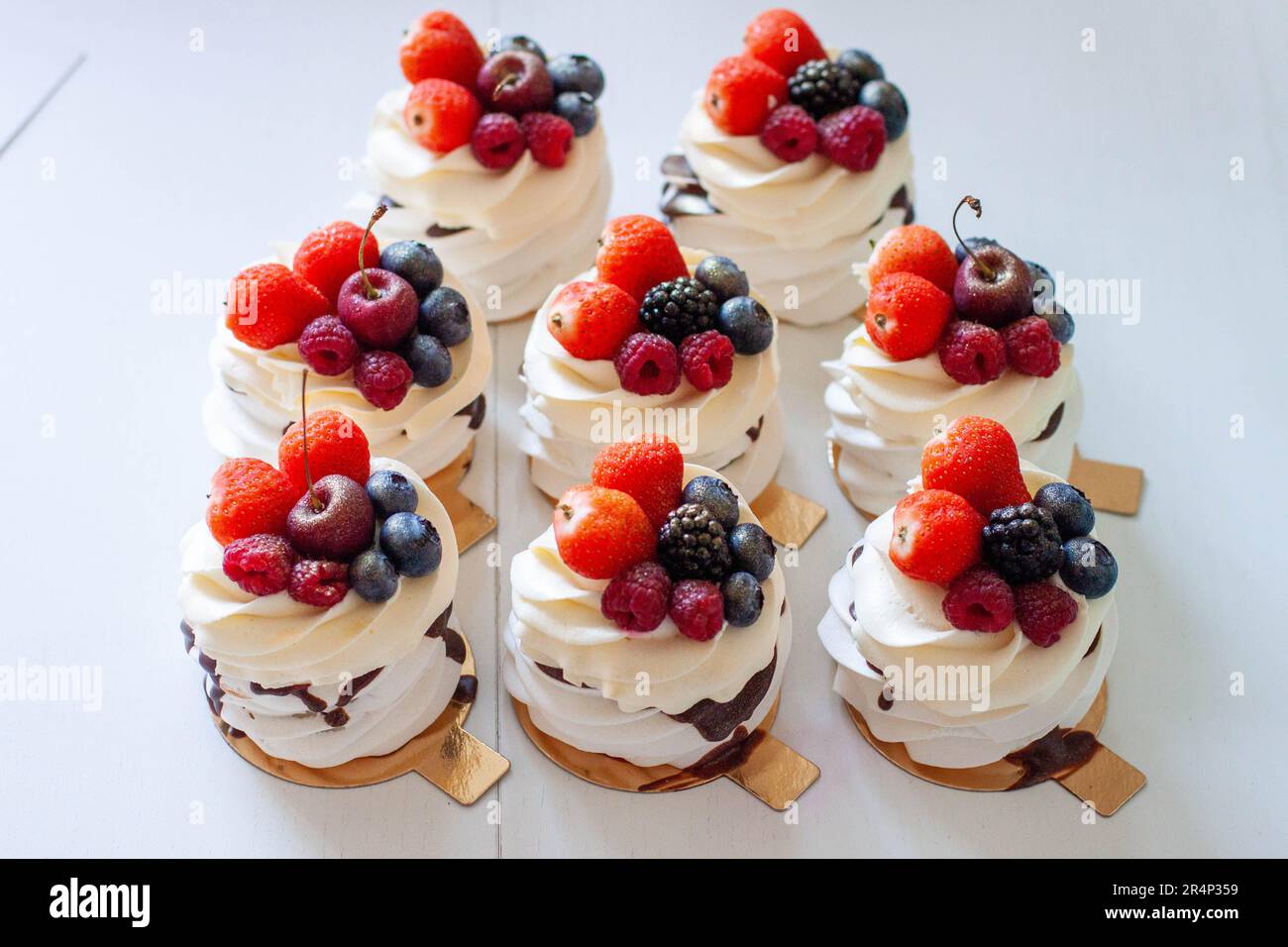 Delicious mini Pavlova meringue cakes decorated with fresh raspberry ...