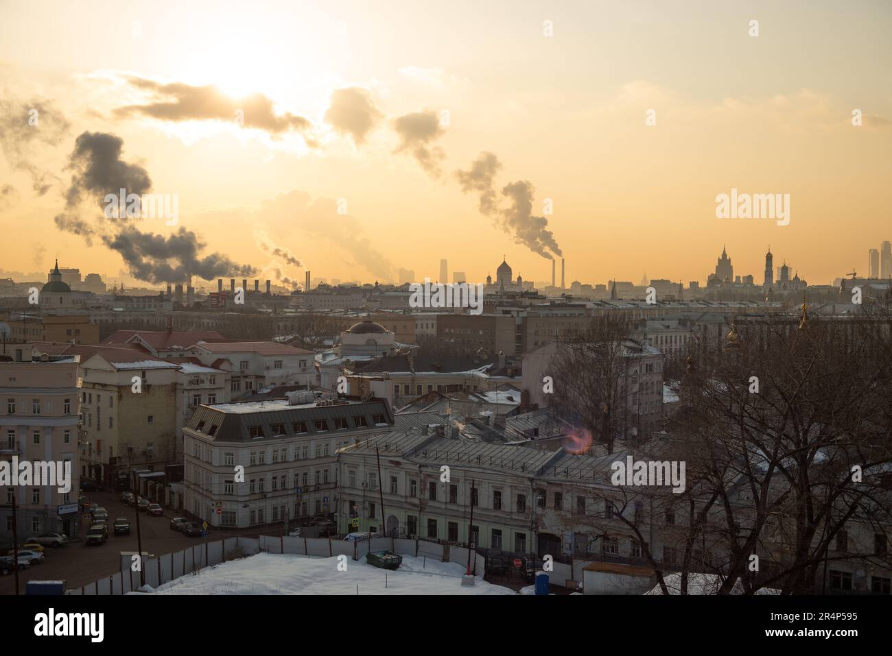 The silhouettes of smoking chimney stacks on the skyline at dusk ...