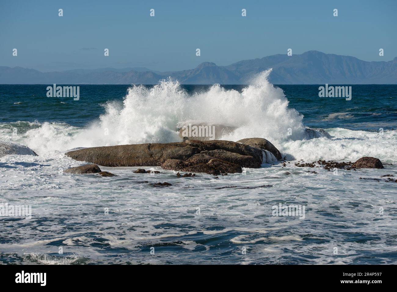 powerful Waves crash over a rock on the beach near Simons Town, Western ...