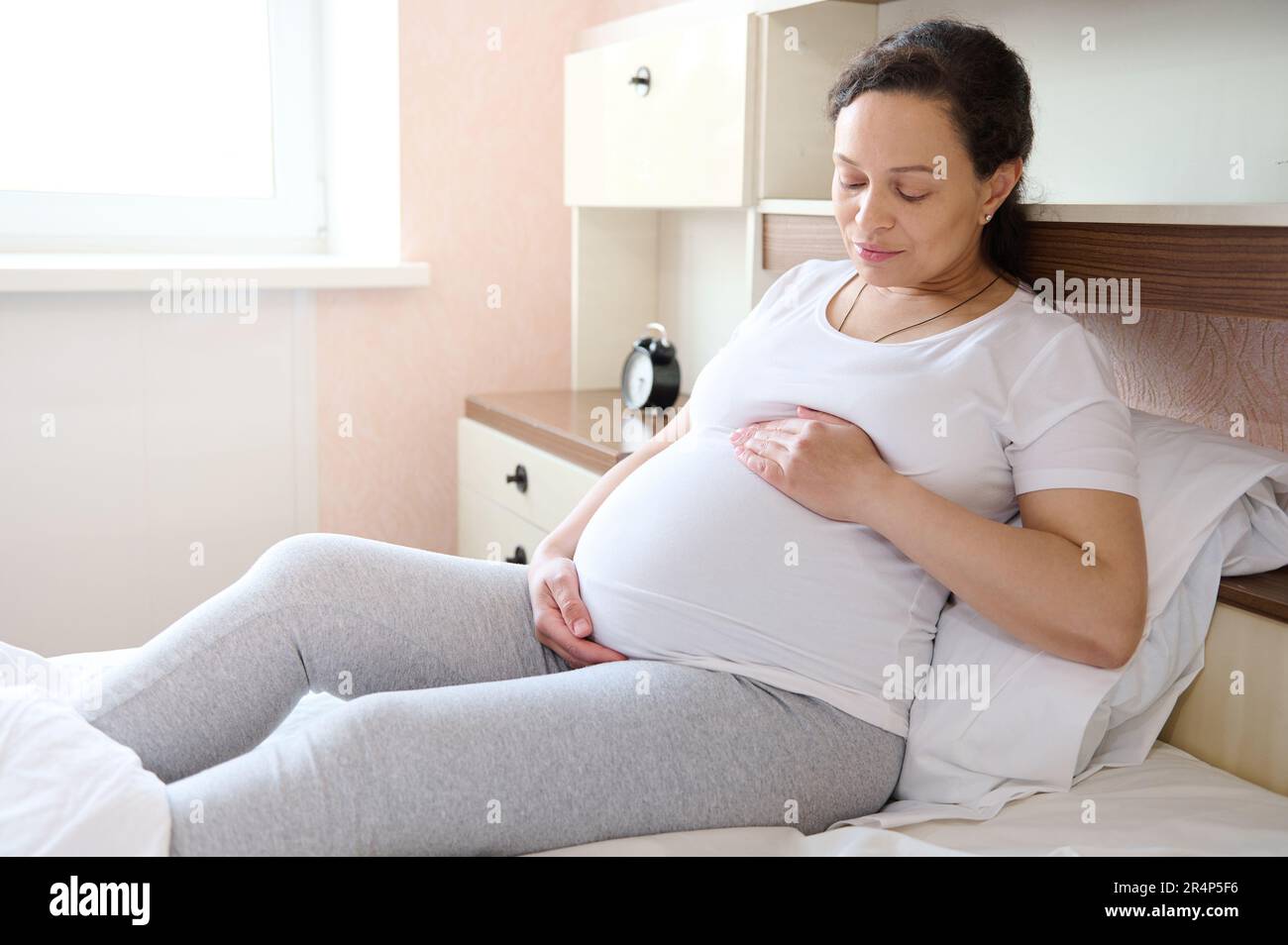 Beautiful Multi Ethnic Pregnant Woman Gently Caressing Her Belly