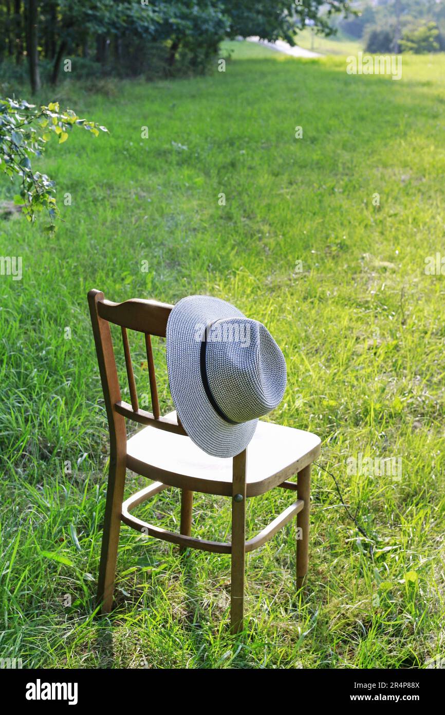 Wooden chair and a hat in the garden. Graphic resources Stock Photo - Alamy