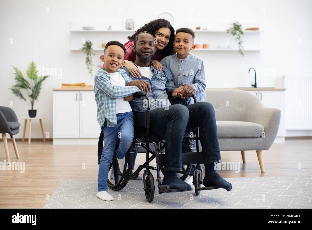 Portrait of multiethnic married couple with two kids posing together in ...
