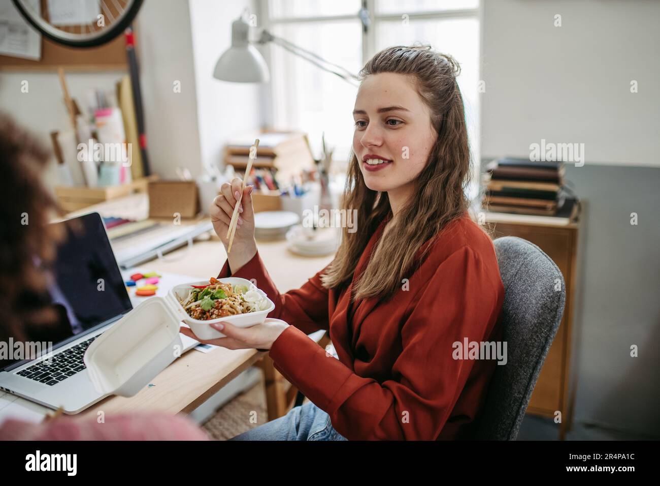 Young colleagues having lunch time in their office Stock Photo - Alamy