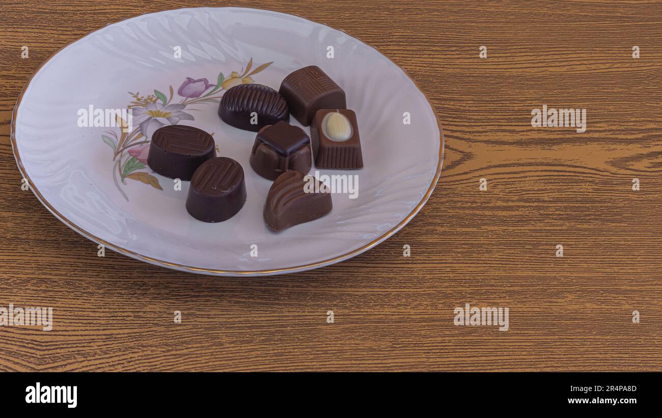 Delicious assorted flavors chocolate candies on white plate Stock Photo ...