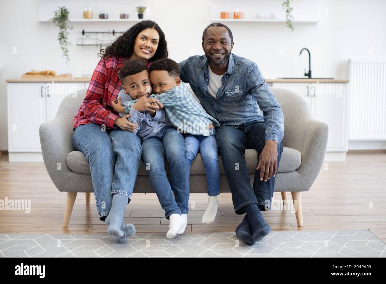 Multicultural brothers hugging each other while sitting between joyful ...