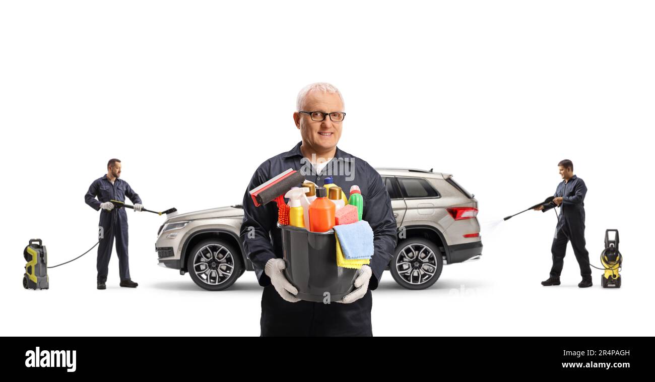 Workers in uniforms washing a vehicle with pressure washer machines and ...