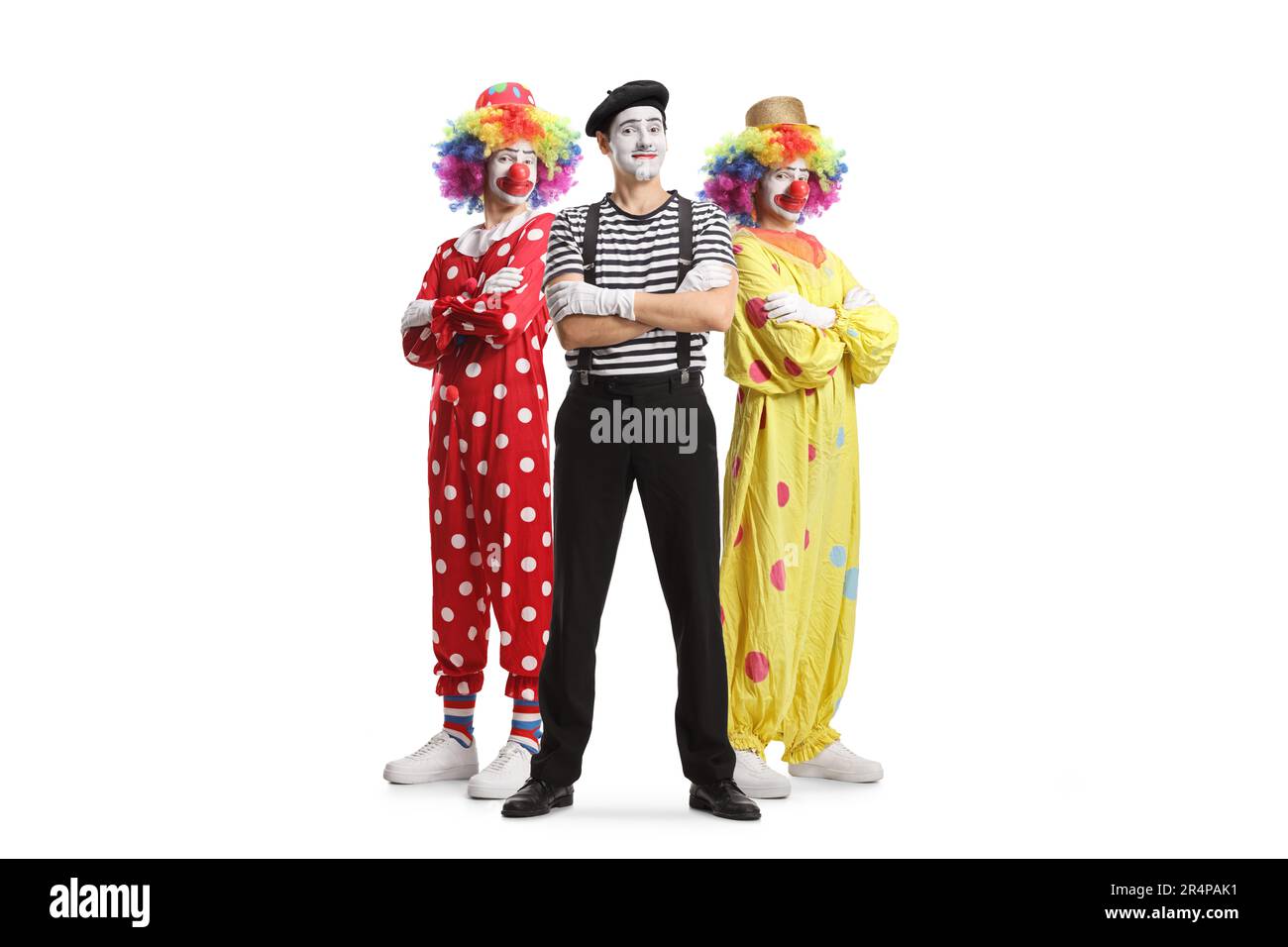 Full length portrait of two clowns and a mime posing with crossed arms isolated on white ...