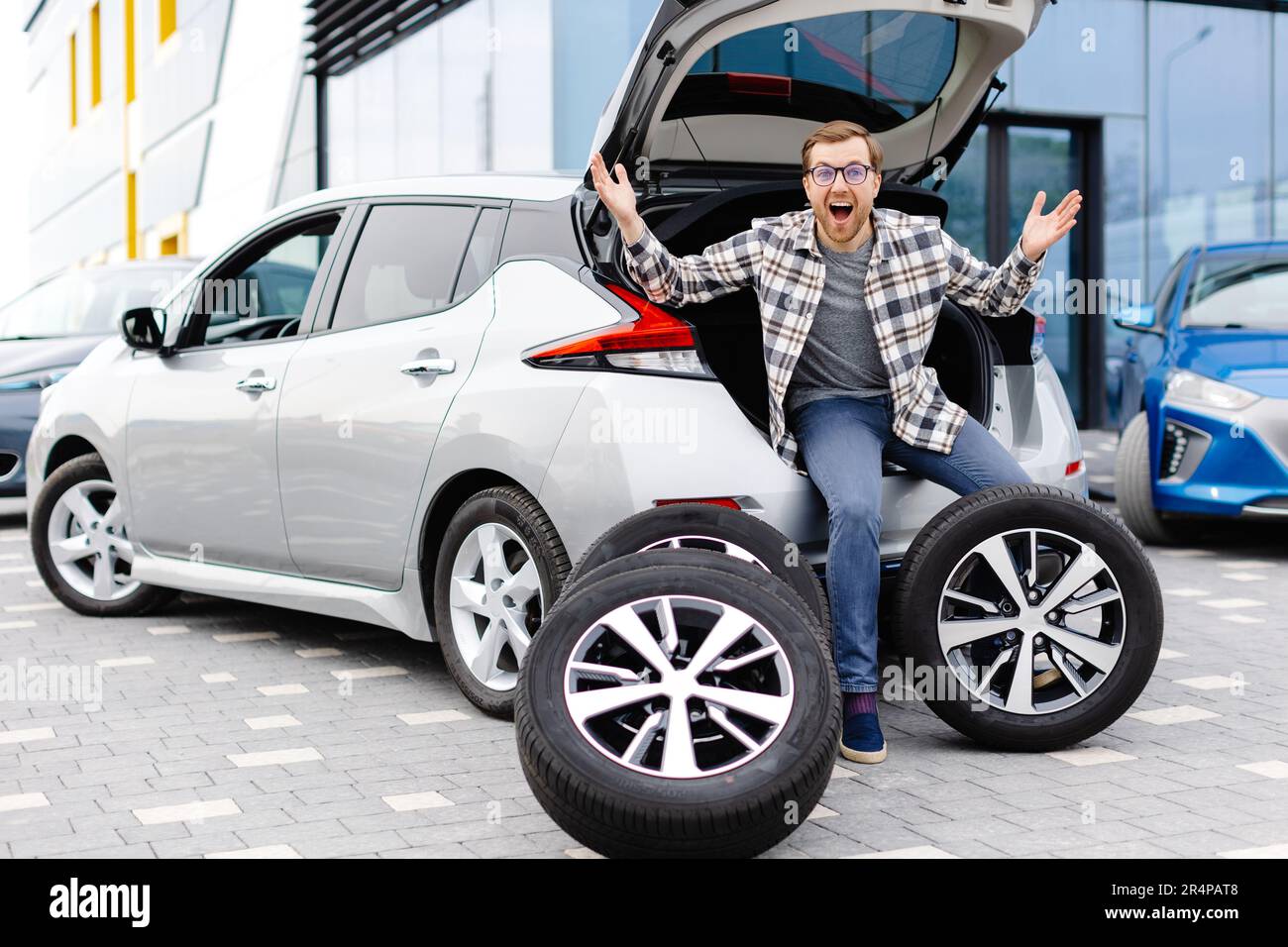 Car mechanic working in car showroom and changing wheel alloy tire ...