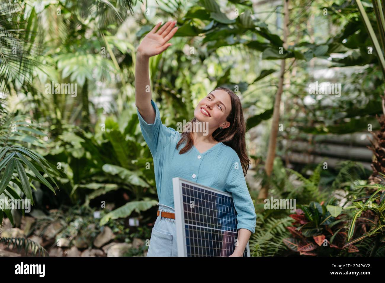 Young woman in botanical garden with photovoltaics panel Stock Photo ...