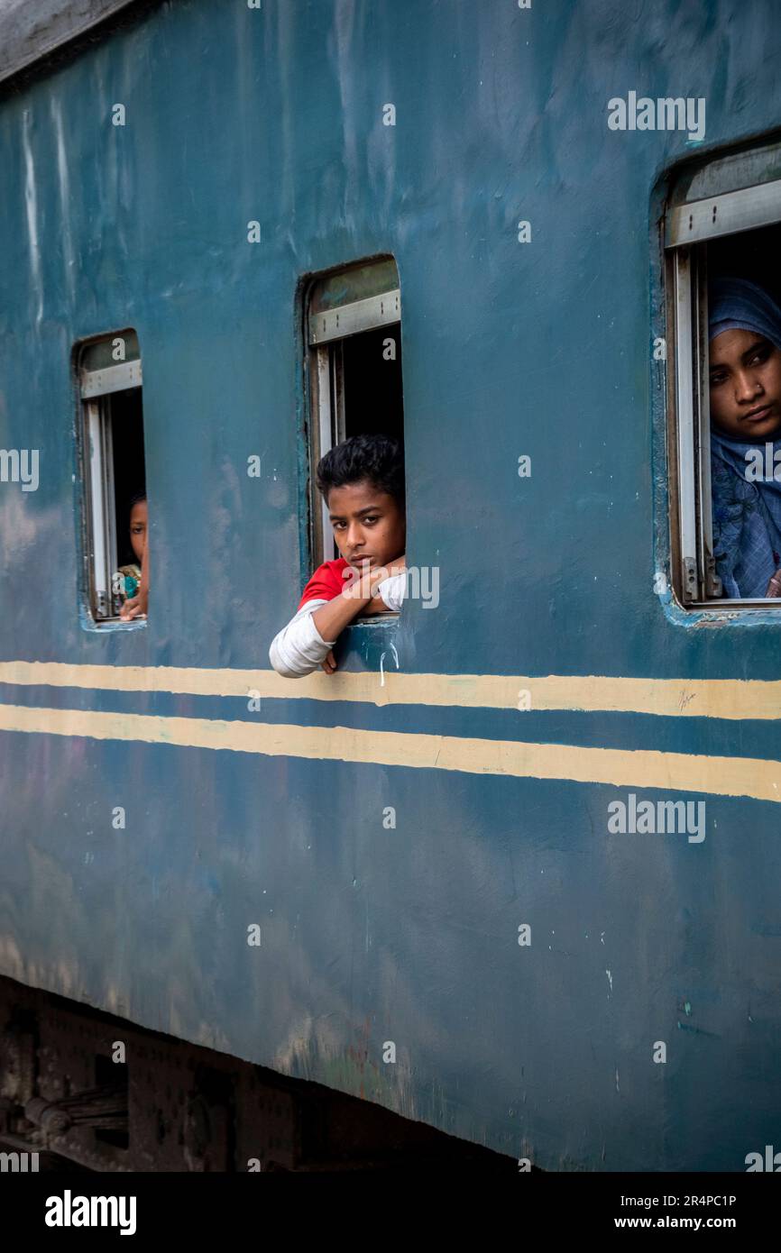 Passengers look out of the windows of a local train in Dhaka ...