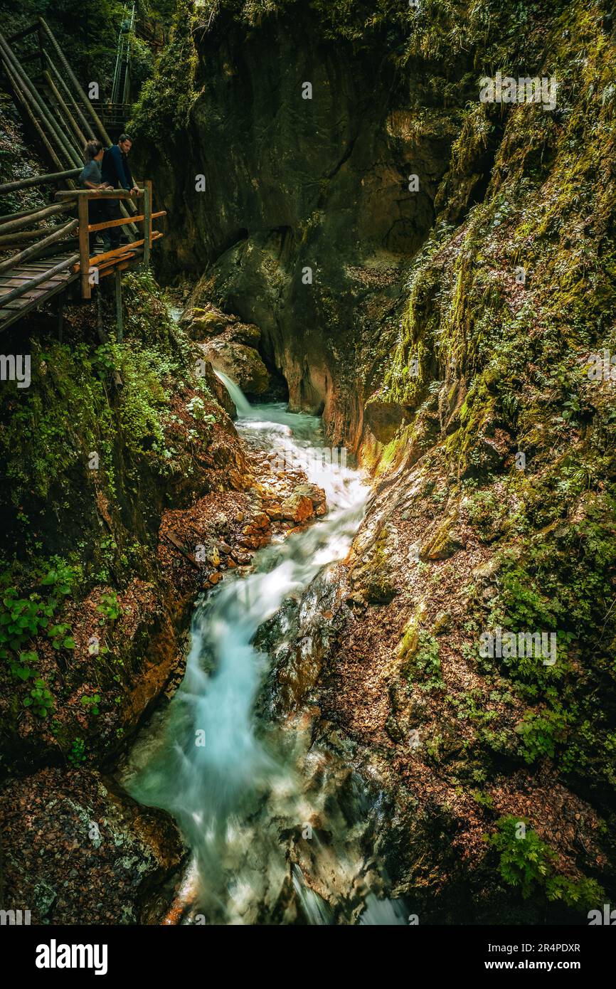 View of hikers looking down at the white water cascading down the rocks ...