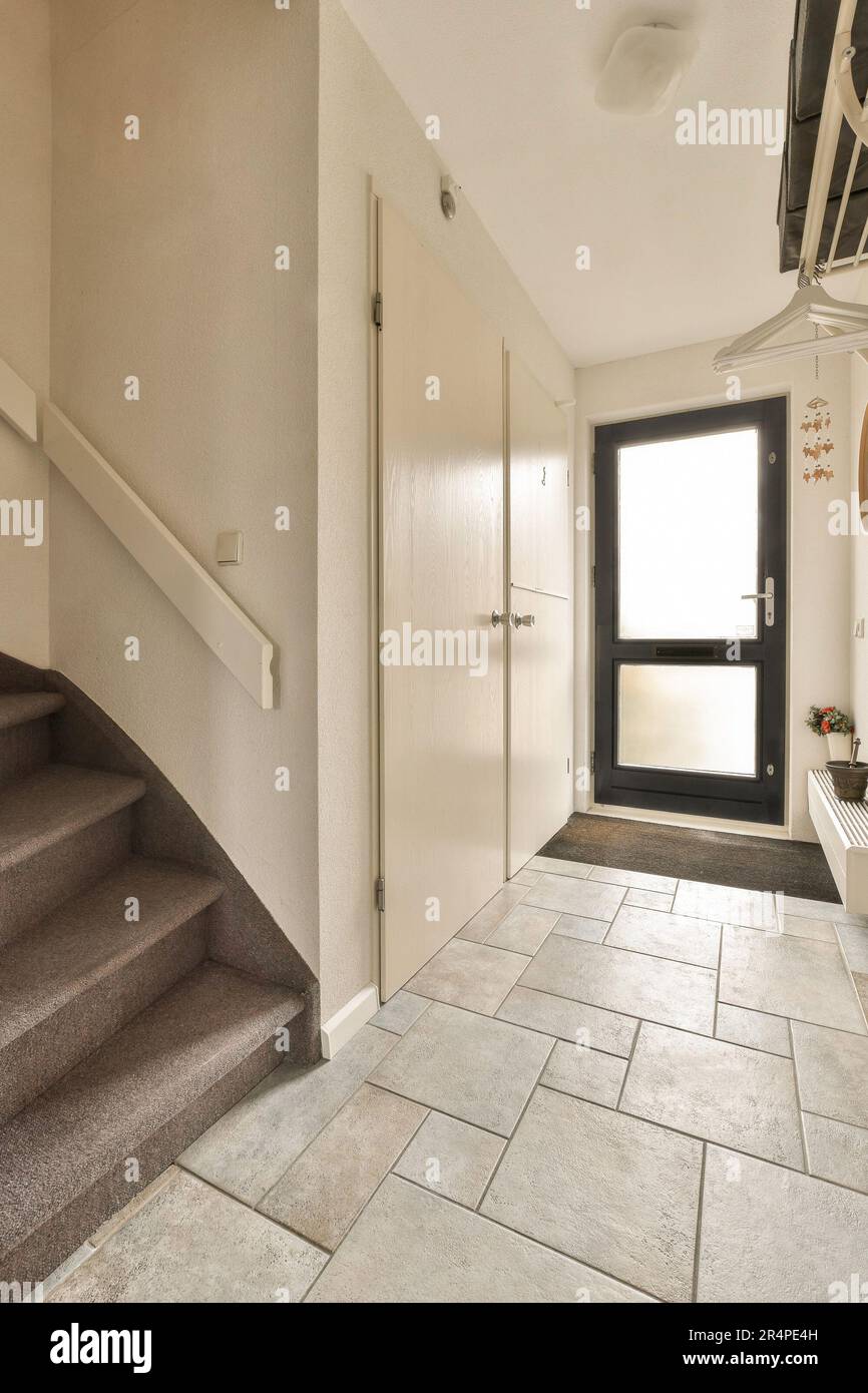 a hallway in a house with stairs leading up to the front door and an ...