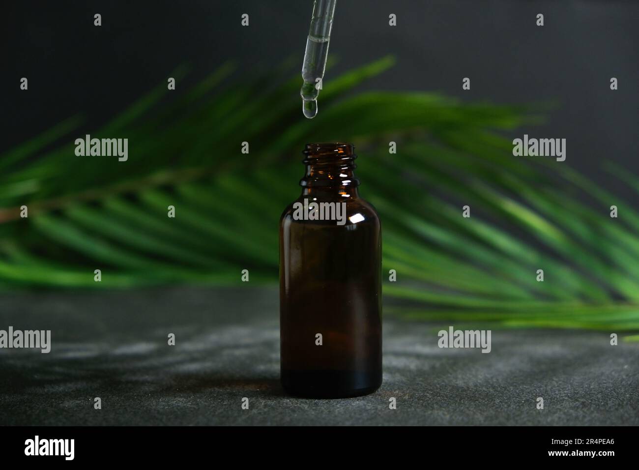 Drop of clear liquid, oil, serum or tincture dripping from pipette in ...