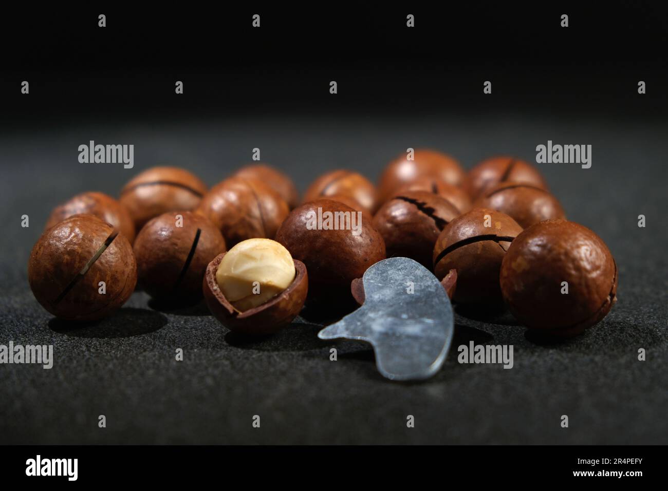 Macadamia nuts with a key on a black background Stock Photo - Alamy